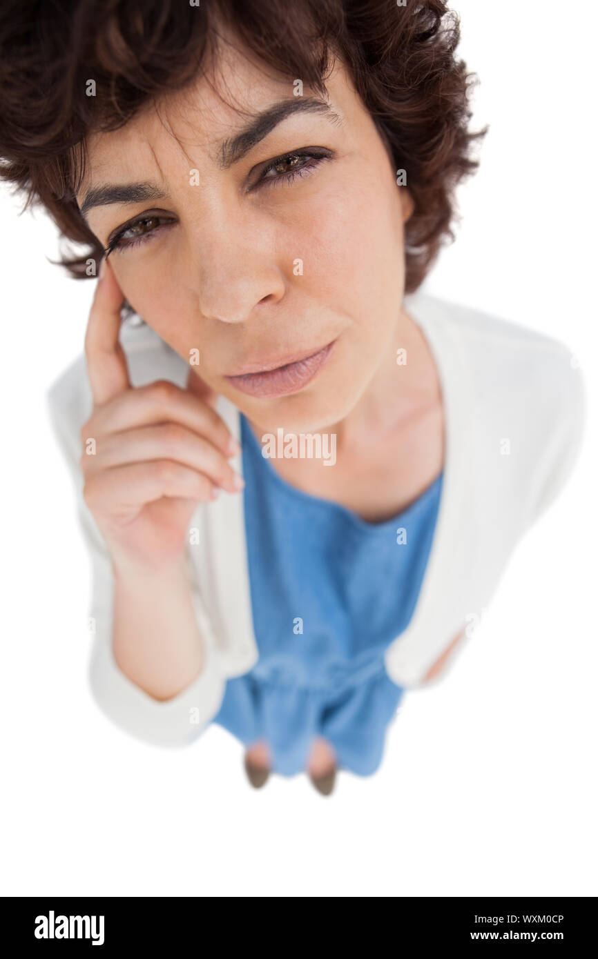 Overhead of standing woman pointing her temple on white background ...