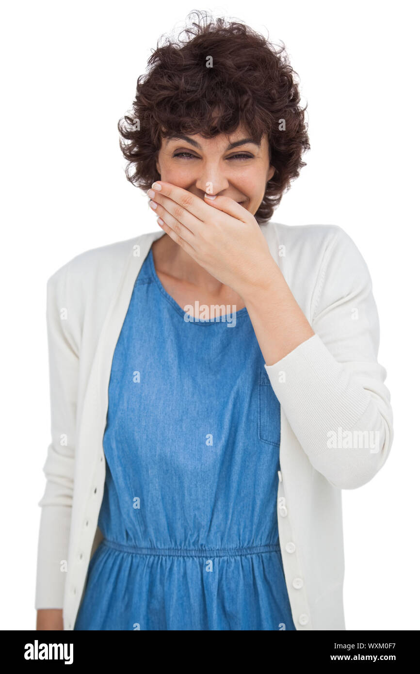 Smiling woman placing her hand on her mouth on white background Stock ...