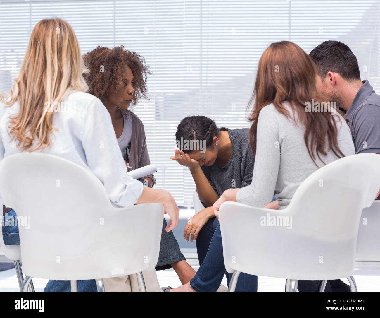 Psychologist taking notes while woman crying at group therapy Stock ...