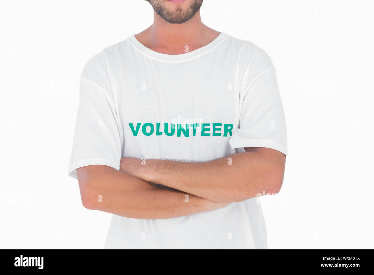 Man wearing volunteer tshirt with arms crossed on white background ...