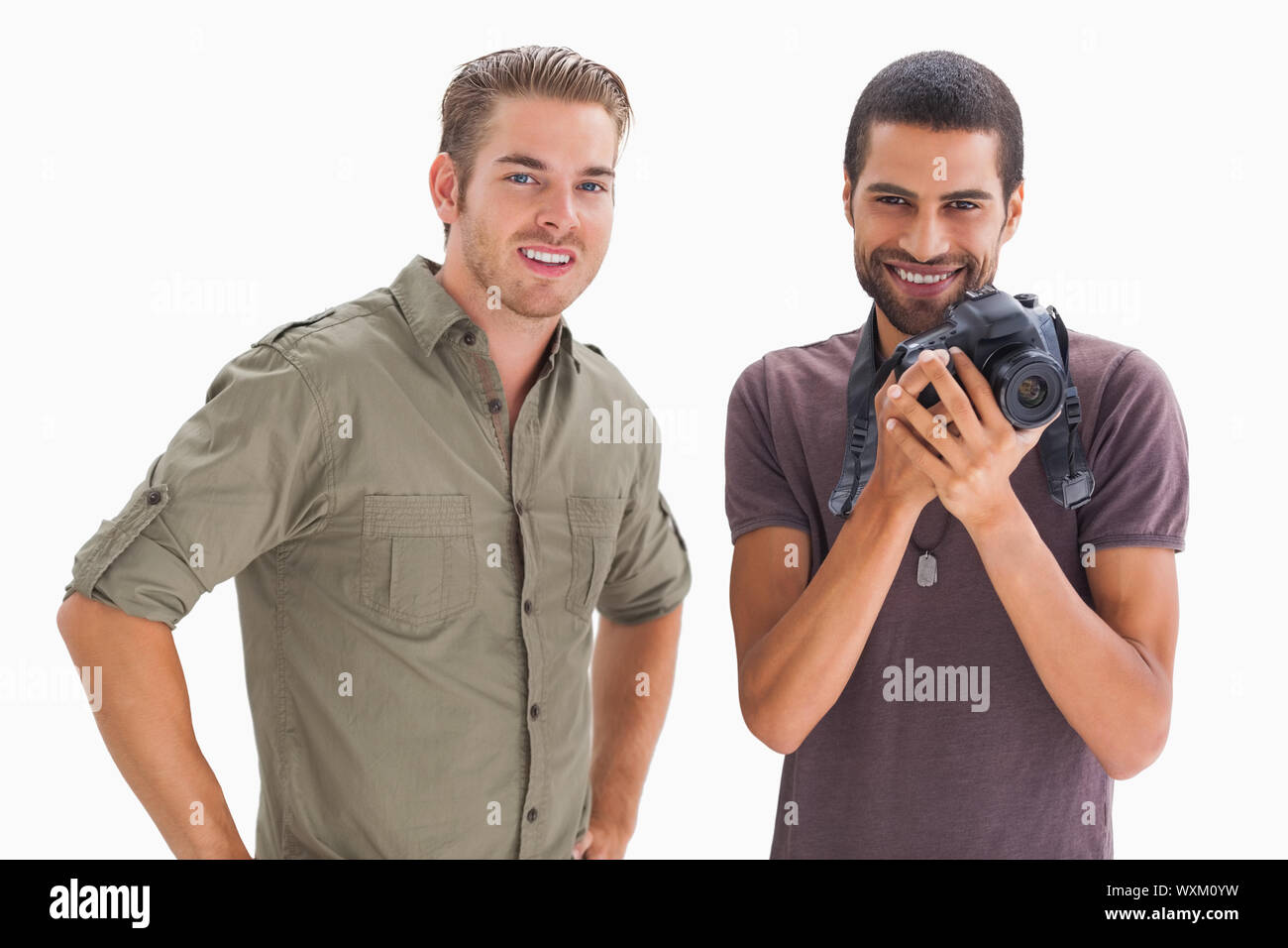 Stylish friends smiling with one holding camera on white background ...