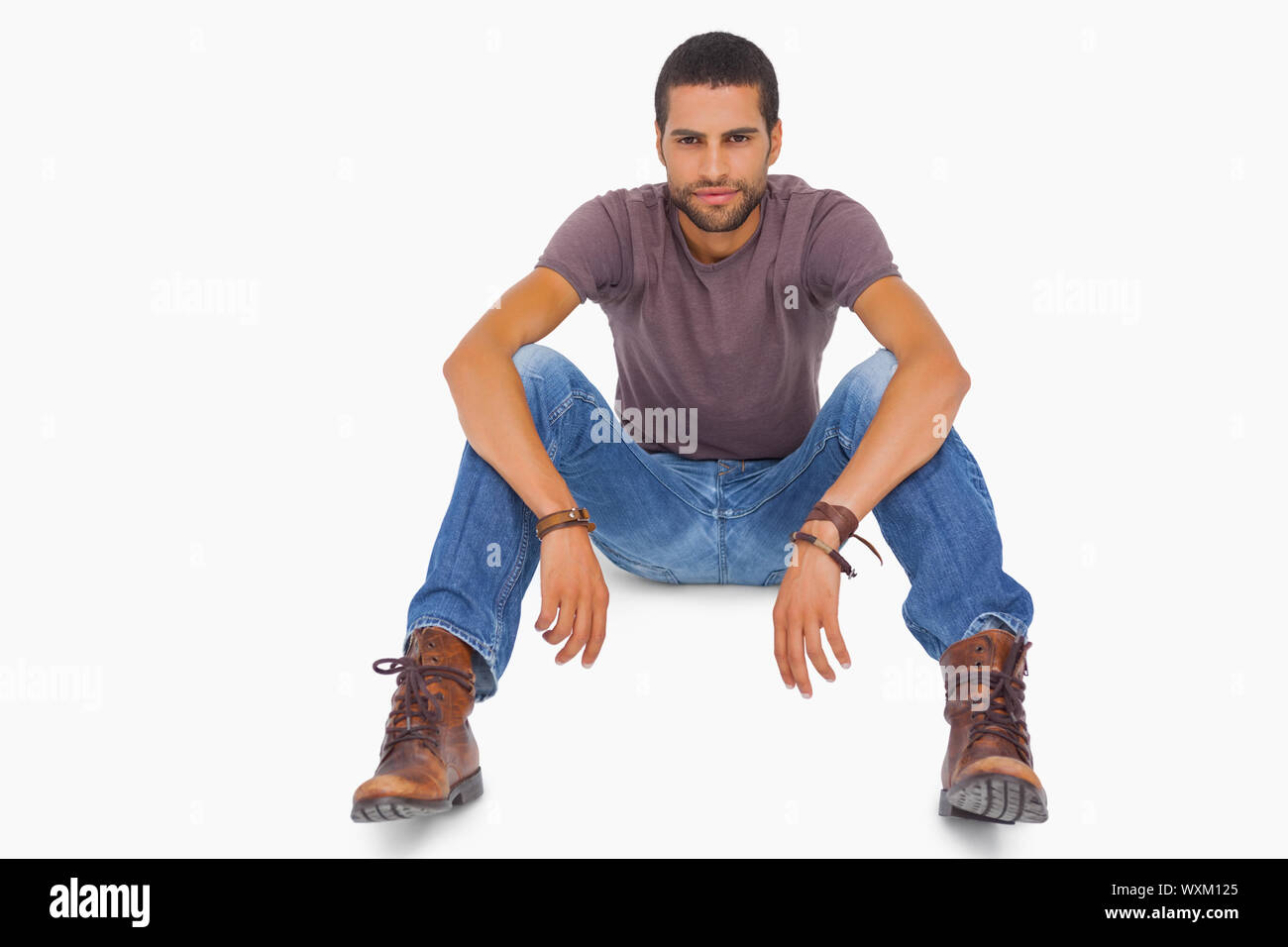 Handsome man sitting on floor on white background Stock Photo - Alamy