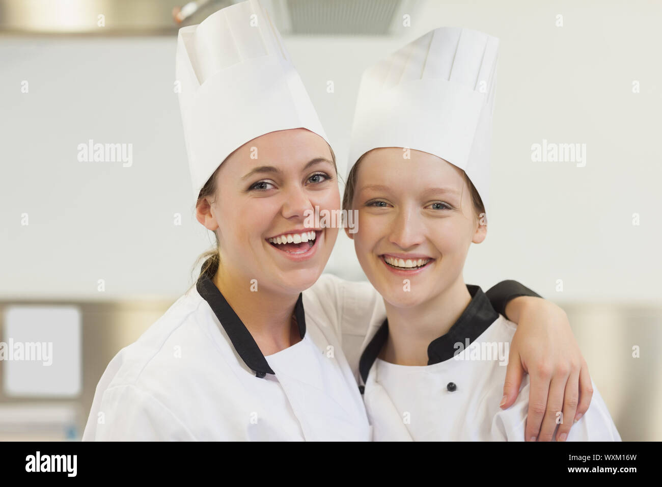 Two chefs smiling together with ones arm around another Stock Photo - Alamy
