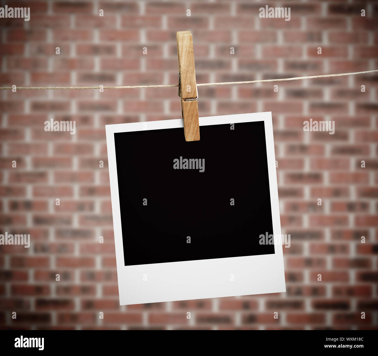 Instant photo hung with peg with bricks on the background Stock Photo ...