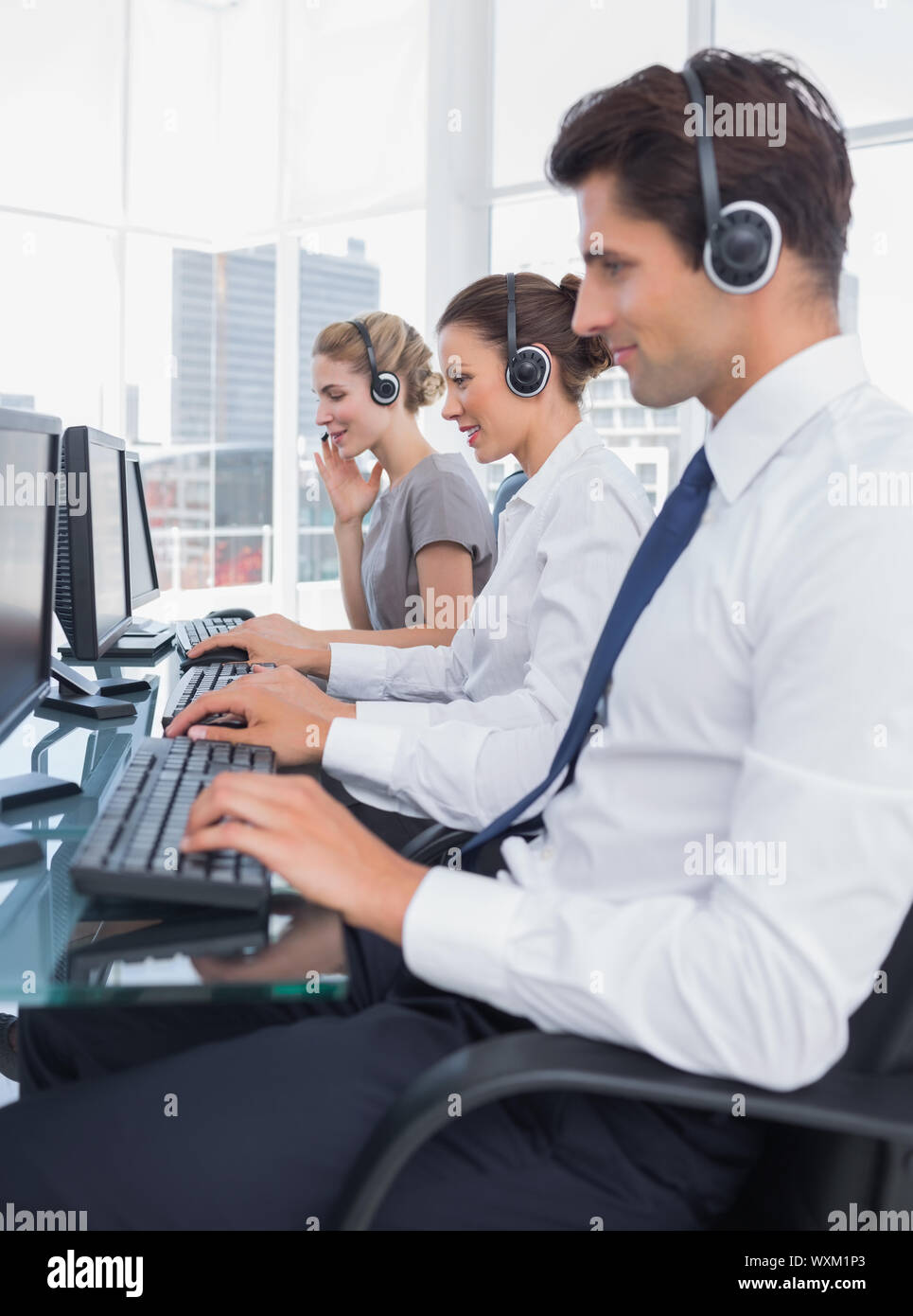 Group of call center employees working in line in a bright office Stock ...