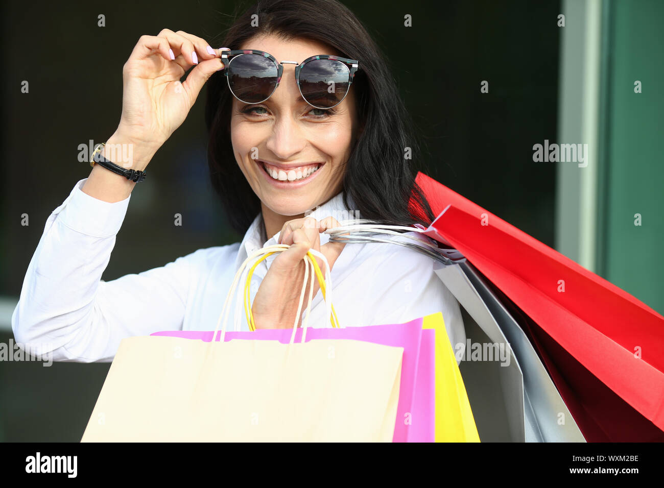 Perfect lady holding packages on shoulder Stock Photo - Alamy