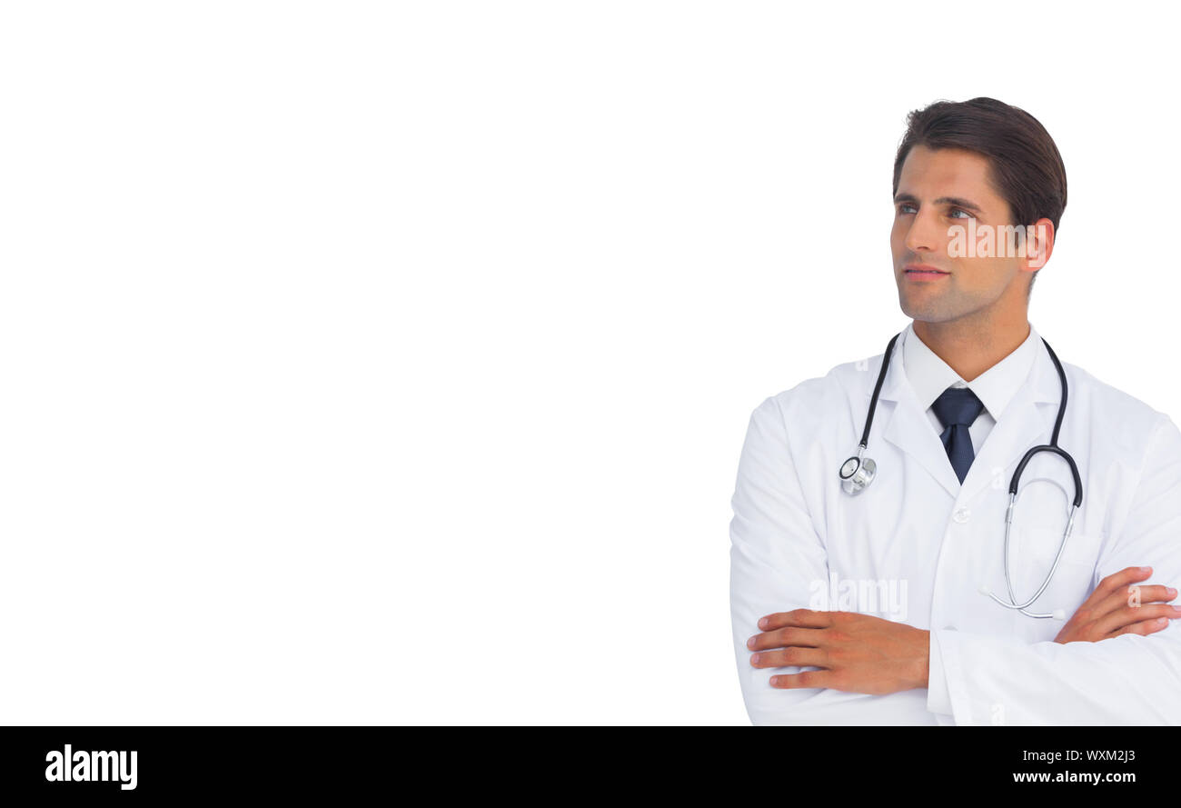 Confident doctor with arms crossed looking up on white background Stock ...