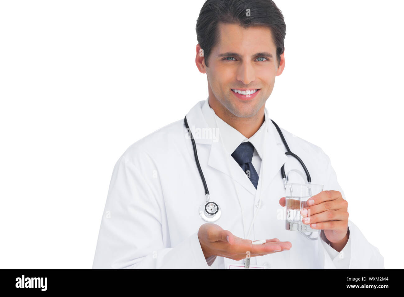 Happy doctor smiling and holding tablets and water on white background ...