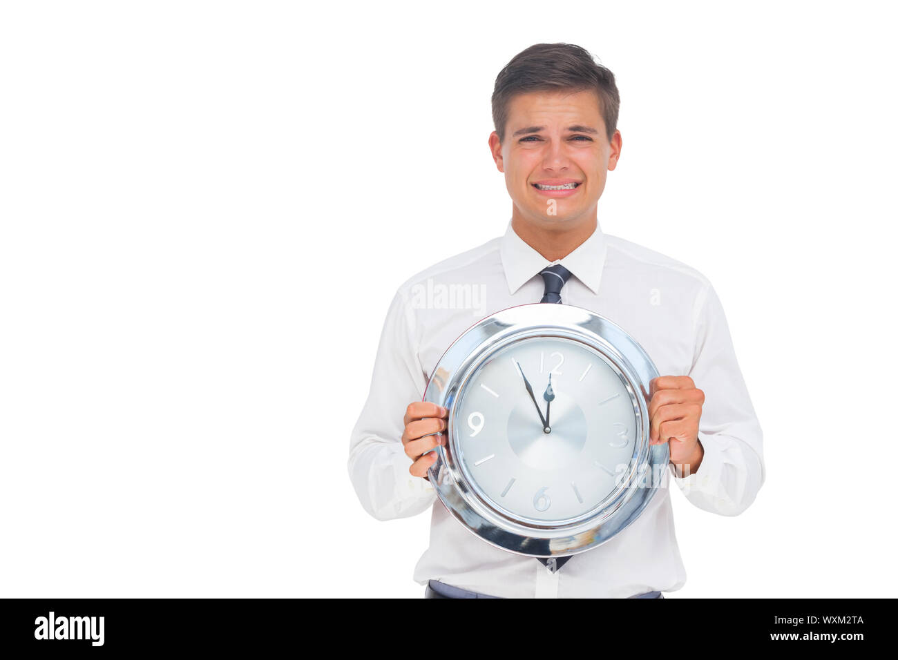 Concerned businessman holding clock on white background Stock Photo - Alamy