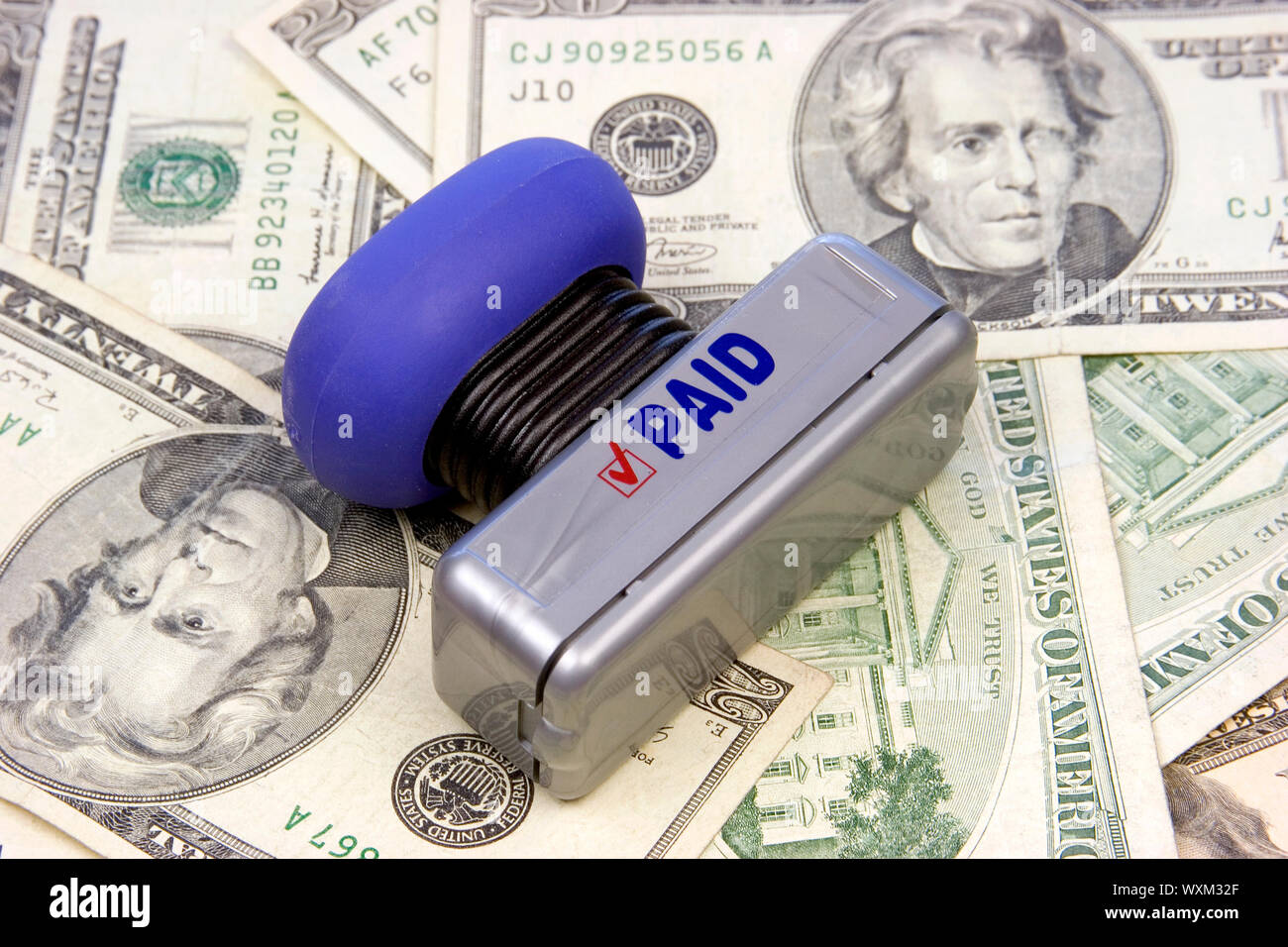 Paid stamp on pile of money Stock Photo - Alamy