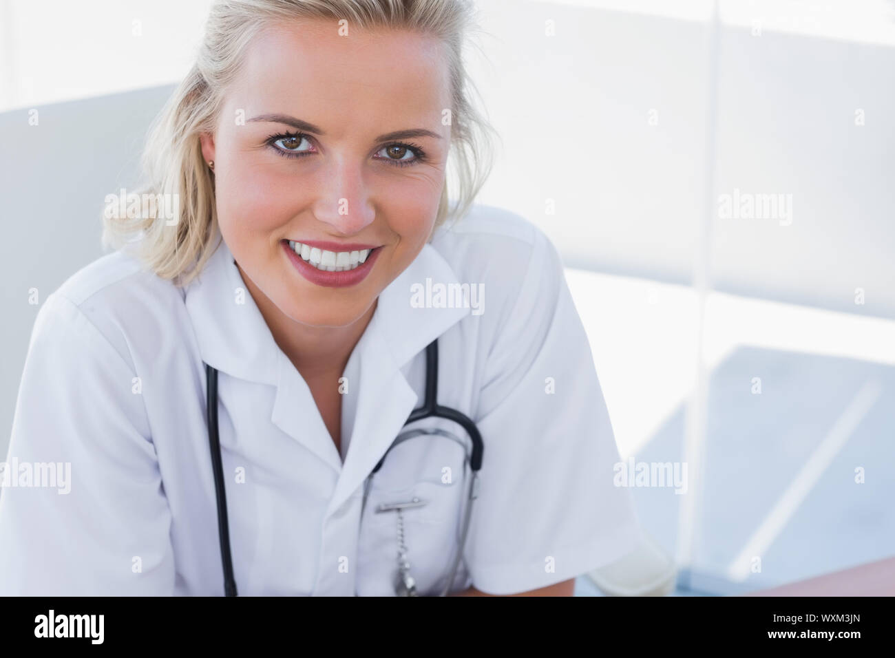 Portrait of a pretty nurse sat in her office Stock Photo - Alamy