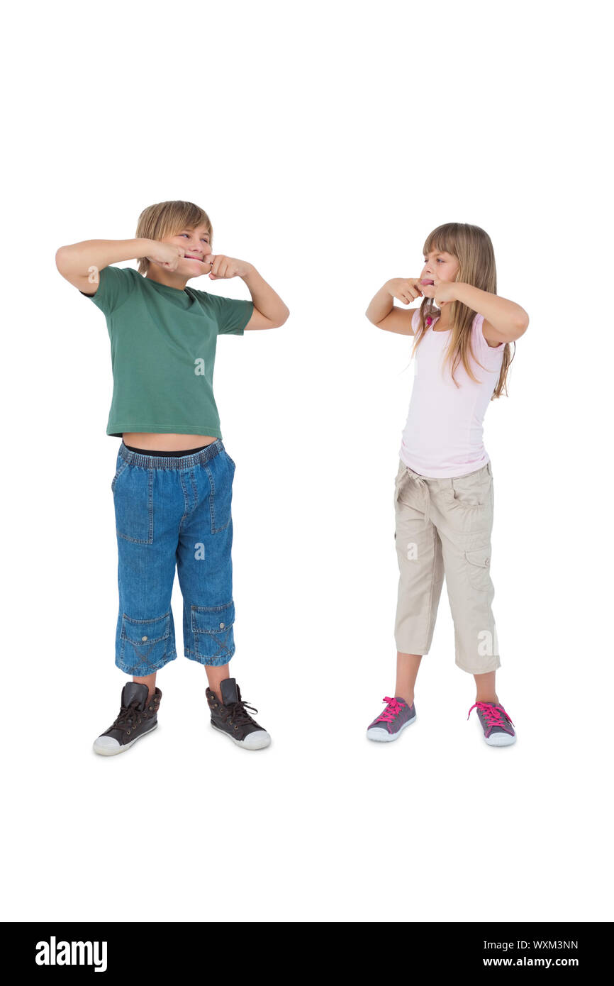 Funny children pulling faces and looking at each other on white ...