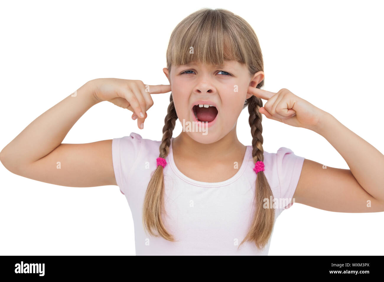Little girl clogging her ears with her fingers on white background ...