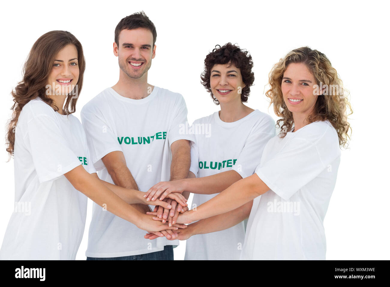 Smiling volunteer group piling up their hands on white background Stock ...