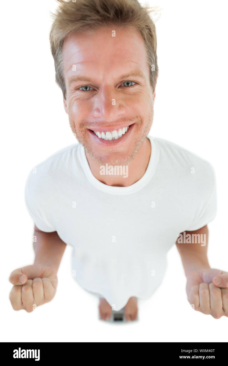 Happy man on a weighing scale on white background Stock Photo - Alamy