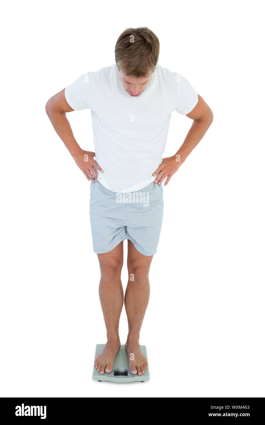 Man looking his weight on a scale on white background Stock Photo - Alamy