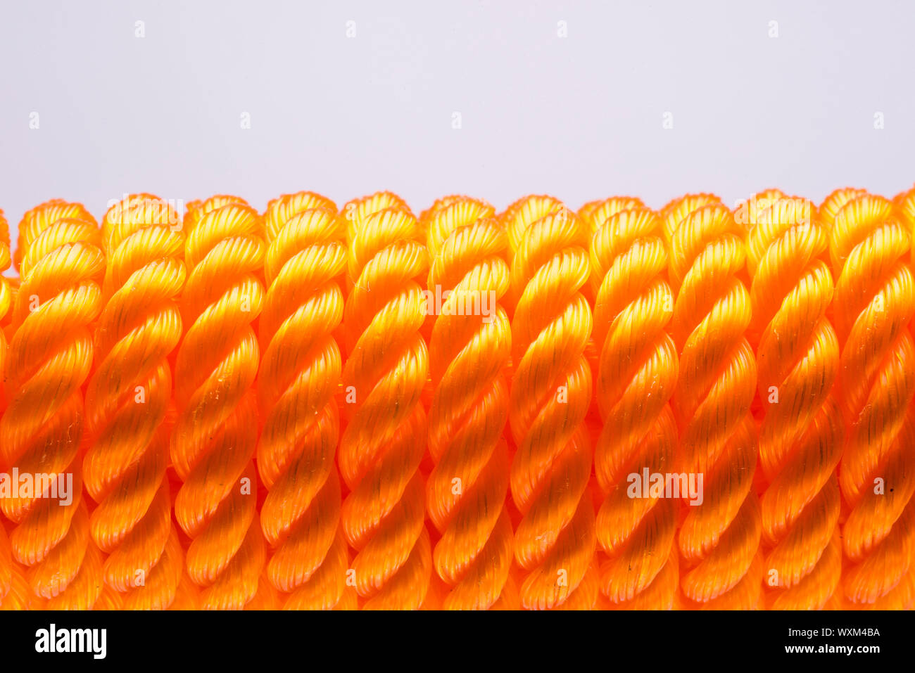 Closeup of orange nylon rope in white background Stock Photo - Alamy