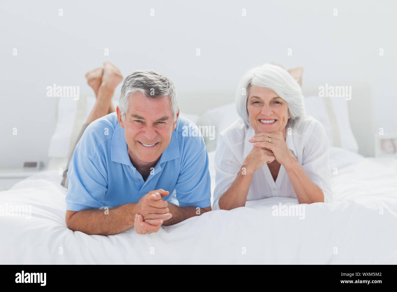 Mature couple lying together in bed Stock Photo - Alamy