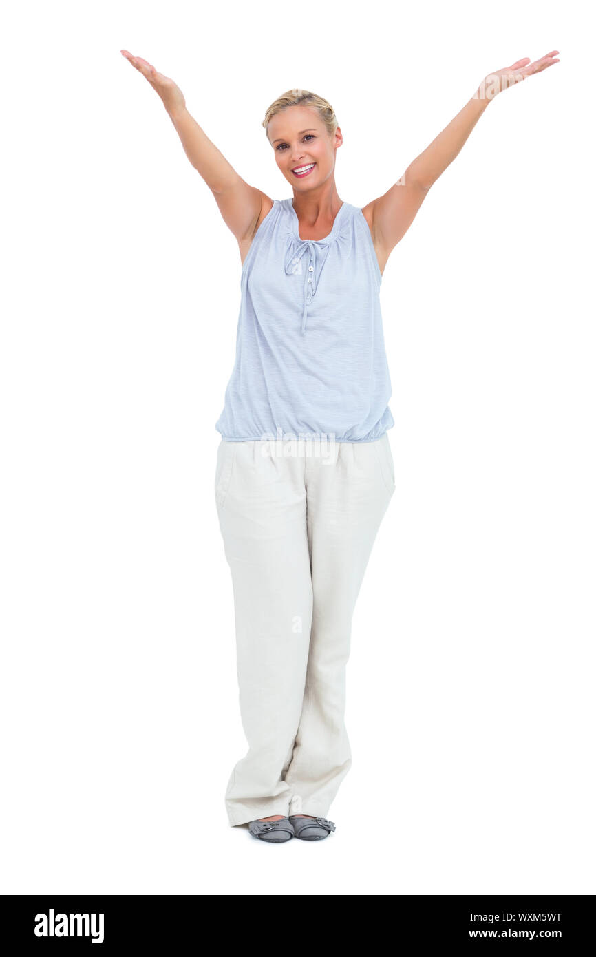 Smiling woman standing with hands up in air on white background Stock ...