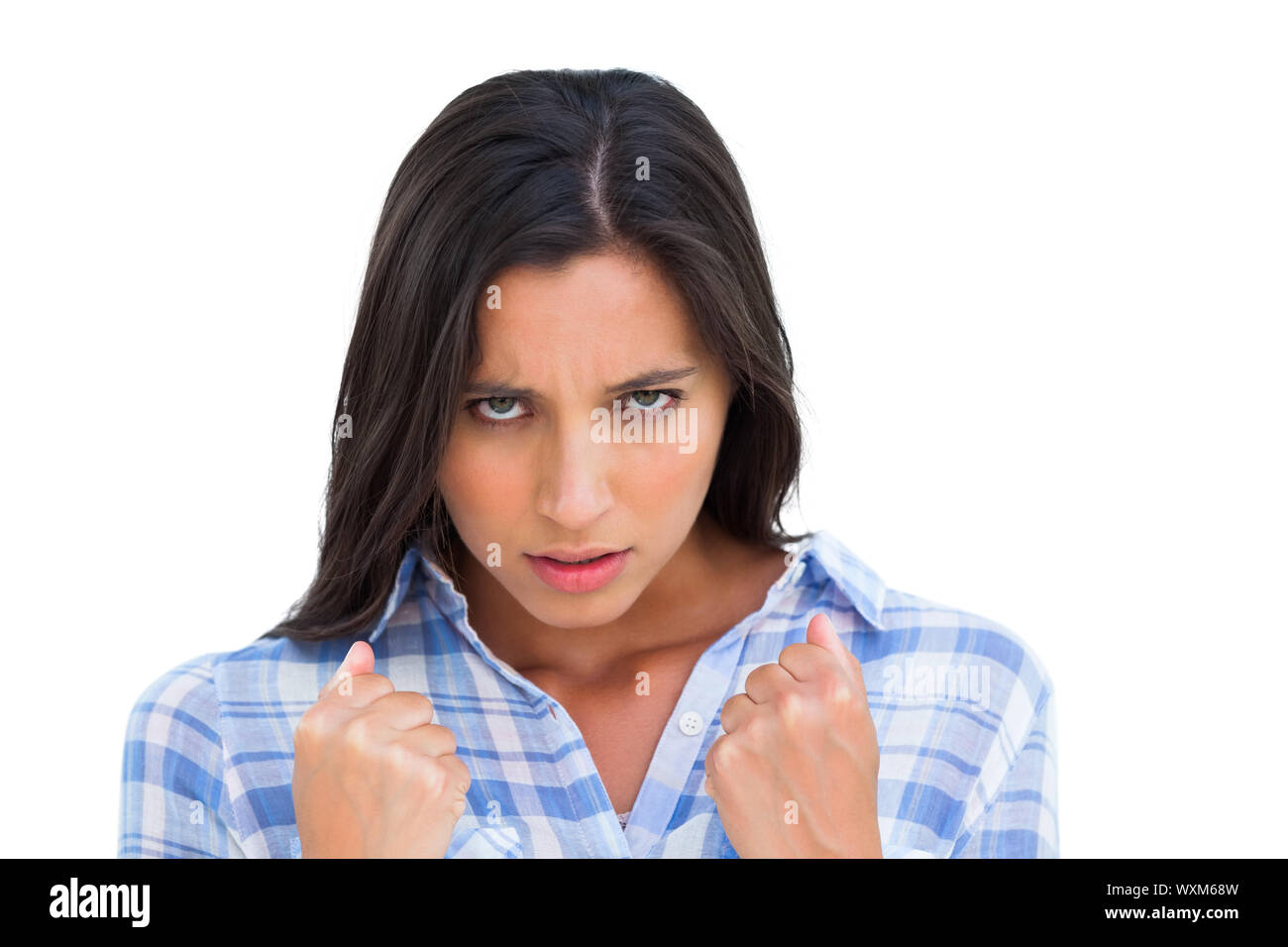 Angry young woman with closed fists looking at camera on white ...