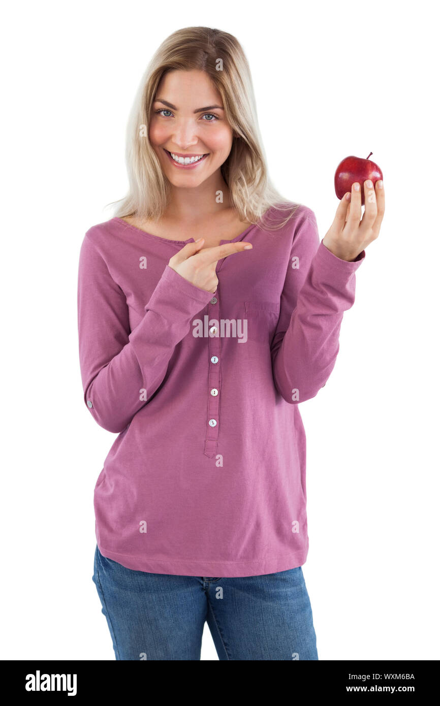 Smiling blonde woman pointing to an apple on a white background Stock ...