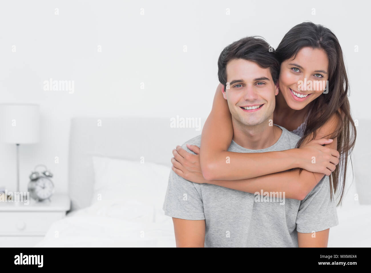 Woman embracing her partner in bed Stock Photo - Alamy