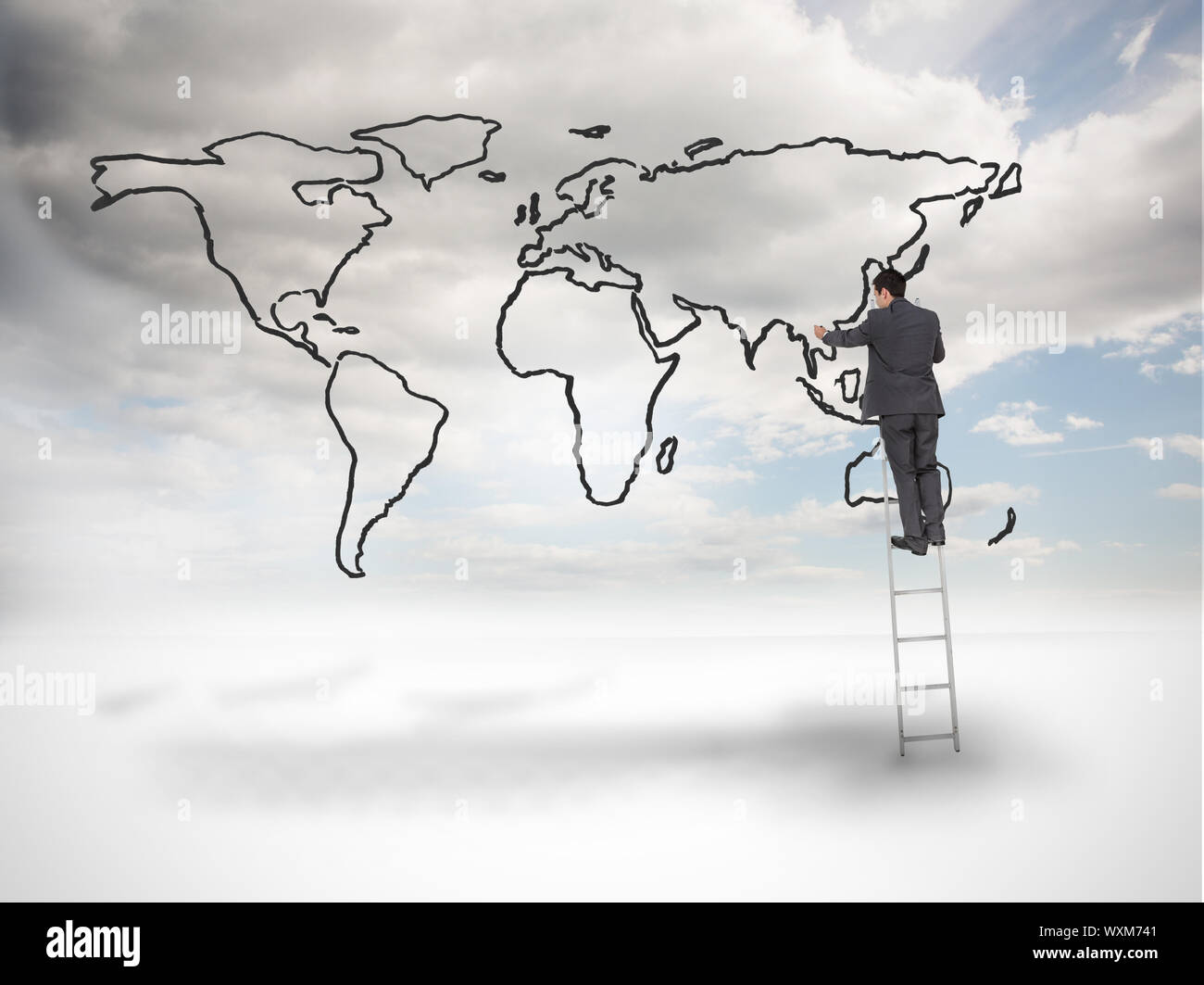 Businessman on a ladder drawing a world map with blue sky on the ...