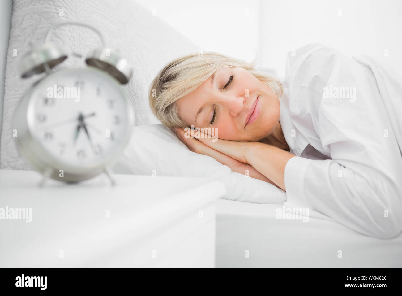 Woman sleeping in bed peacefully at home beside alarm clock Stock Photo ...