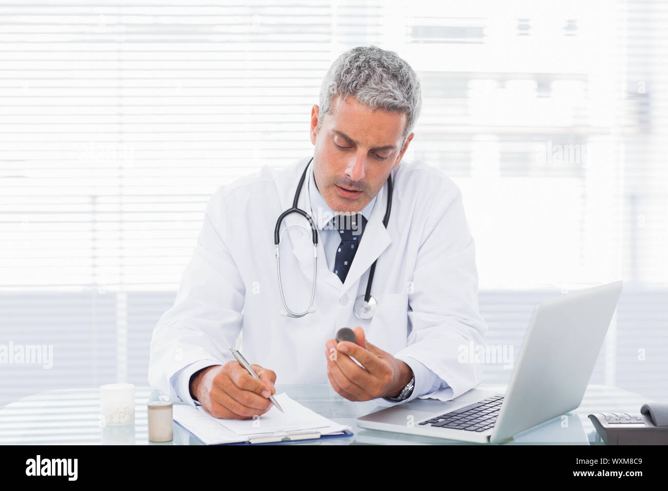 Doctor prescribing medication in office hi-res stock photography and ...