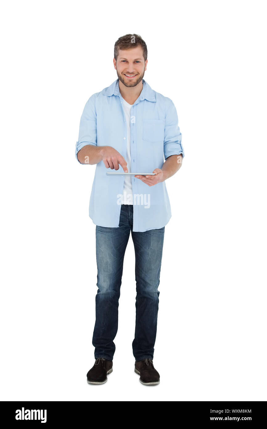 Relaxed male model posing with tablet computer on white background ...