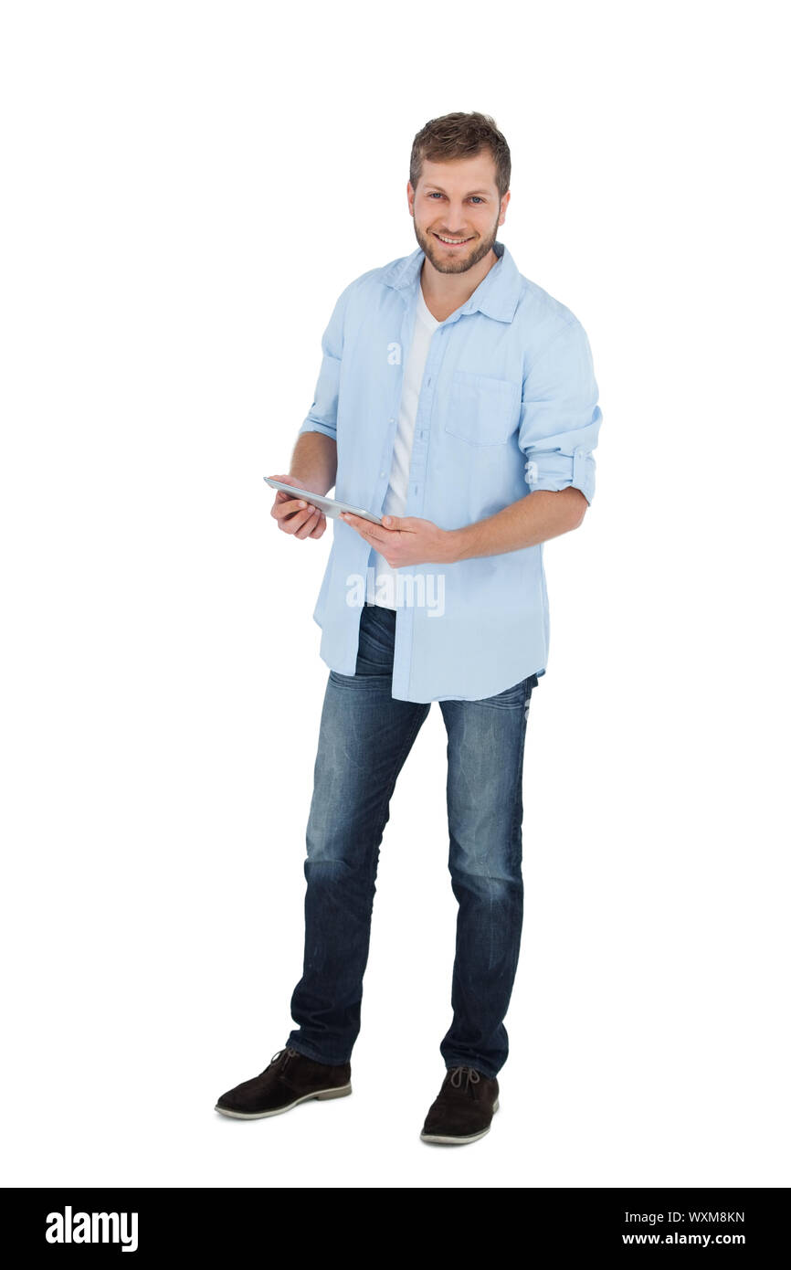 Happy male model using his tablet pc on white background Stock Photo ...