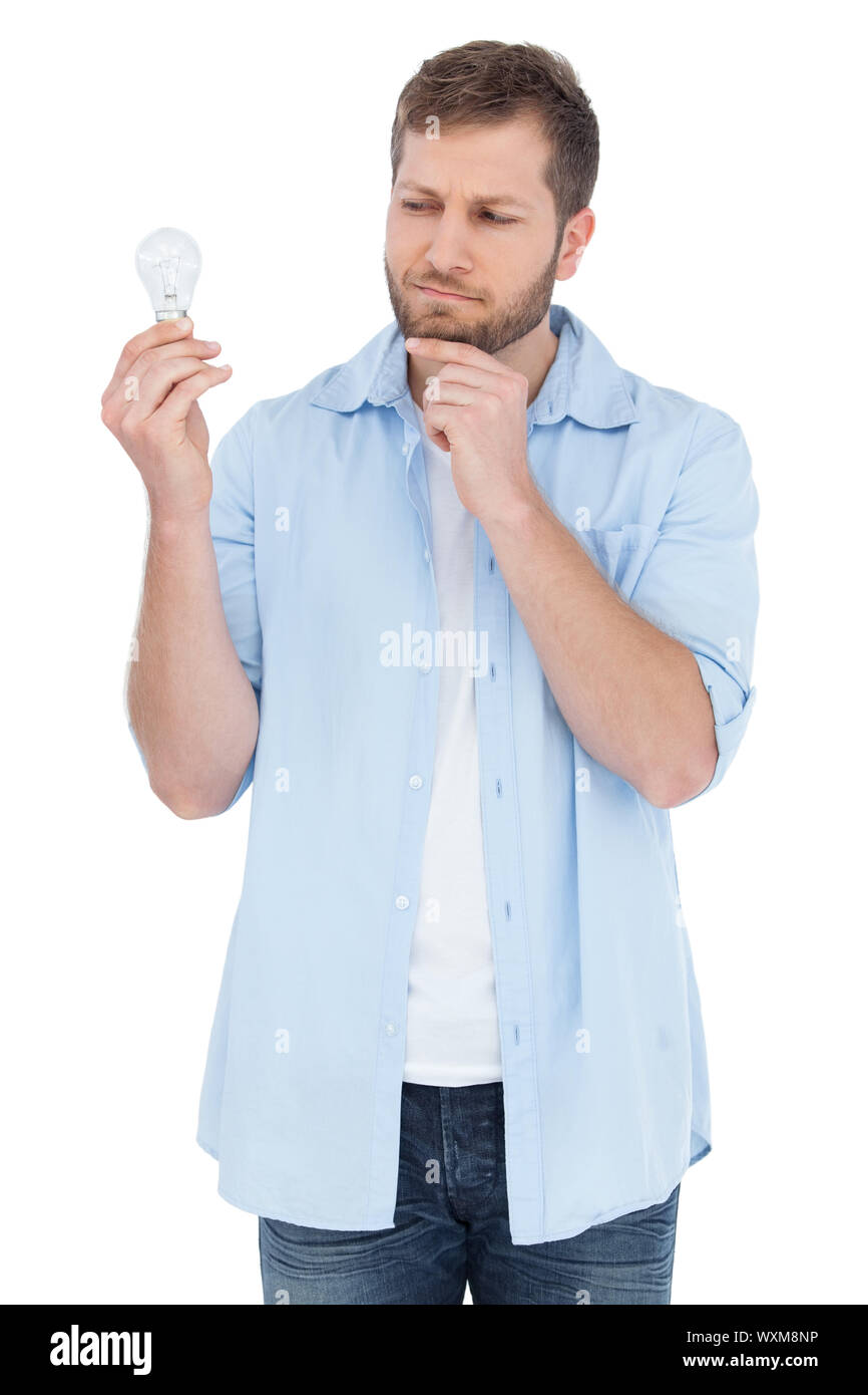 Sceptical model on white background holding a bulb Stock Photo - Alamy