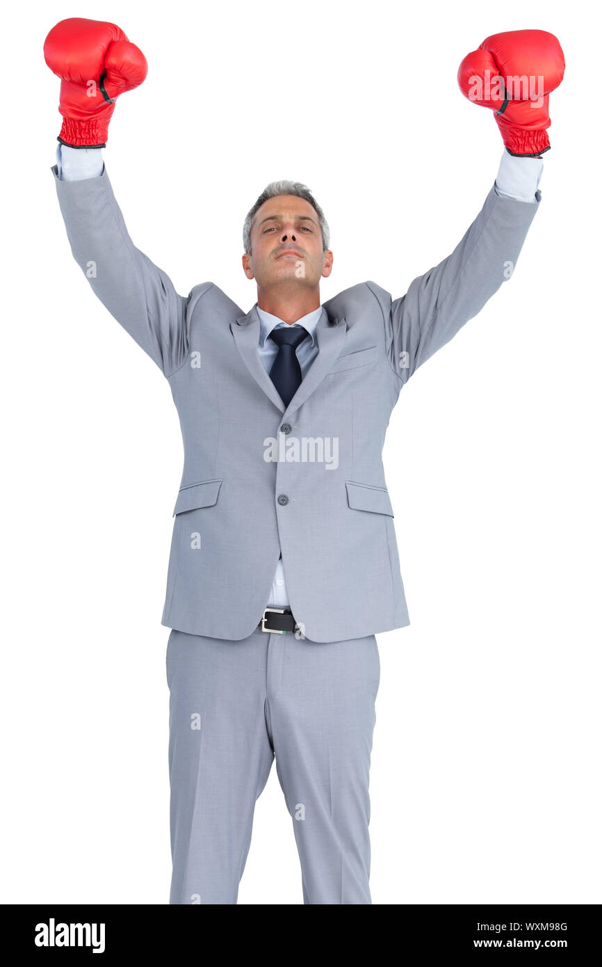 Cocky businessman posing with red boxing gloves on white background ...