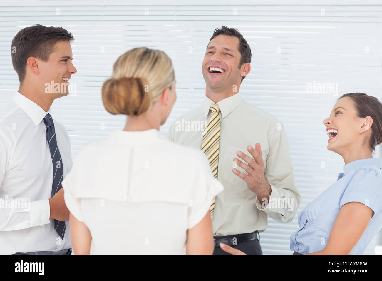 Cheerful colleagues having a break together in staff room Stock Photo ...