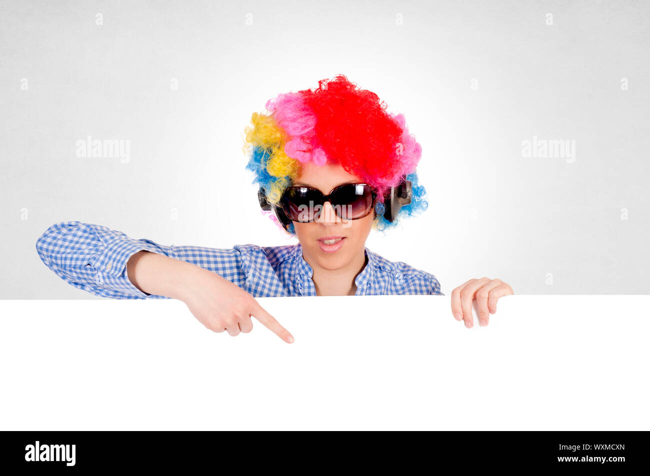 Female with clown wig pointing on the blank white space Stock Photo - Alamy
