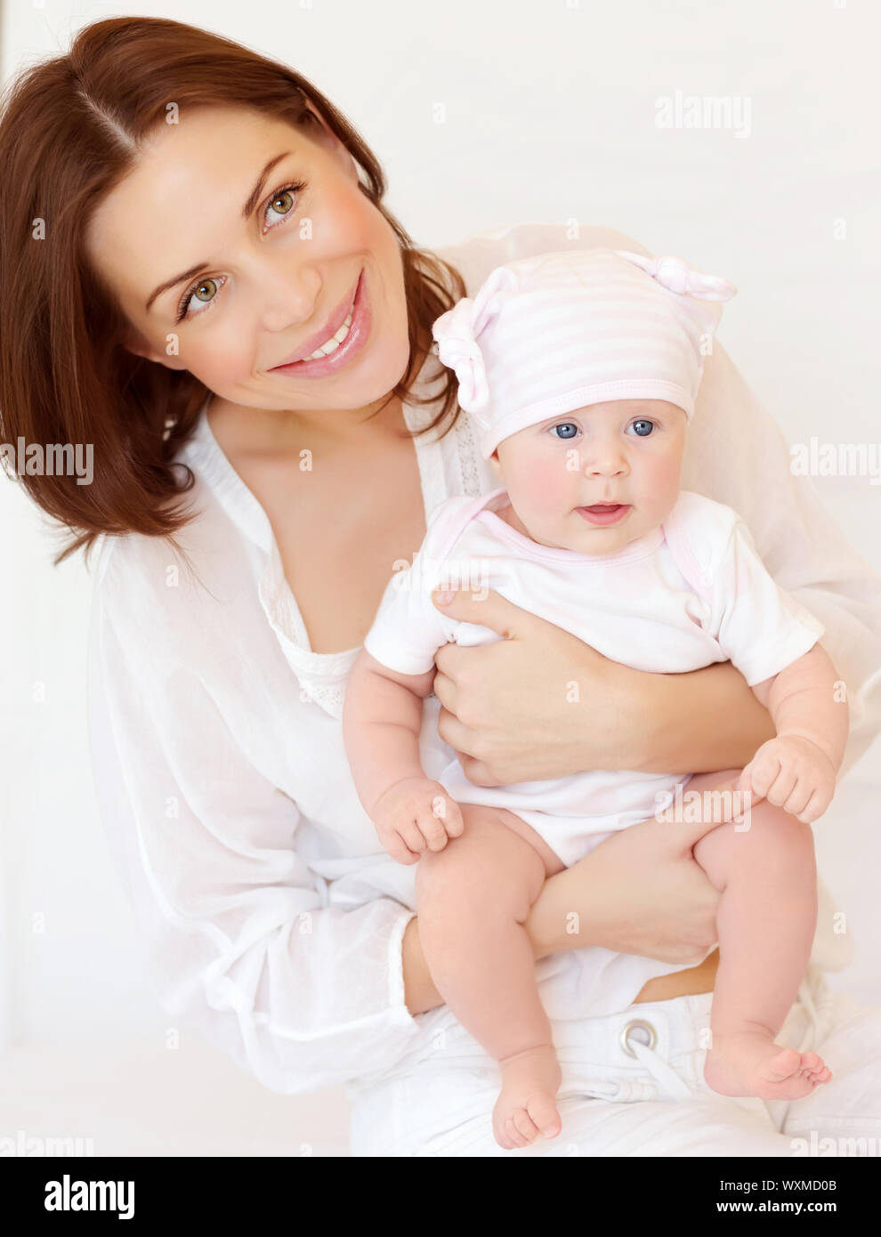 Closeup portrait of cute young mother holding sweet newborn baby, at home, happy family, love ...