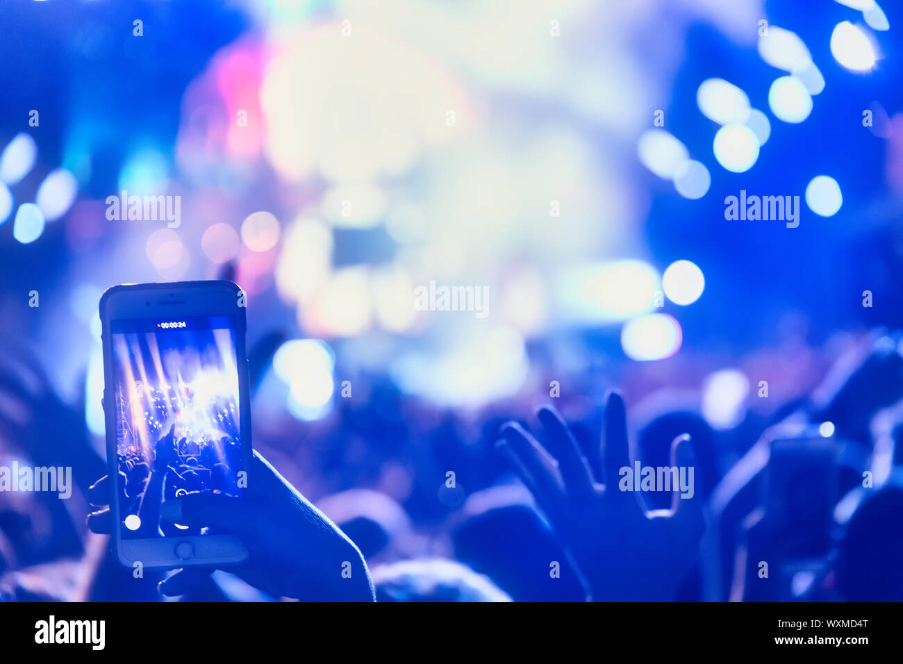 People taking photographs with touch smart phone during a music ...