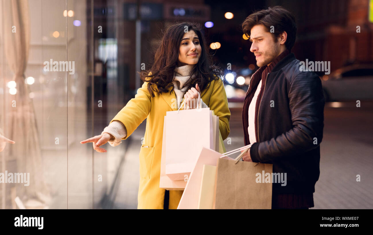 Please, buy! Woman asking boyfriend to buy clothes Stock Photo - Alamy