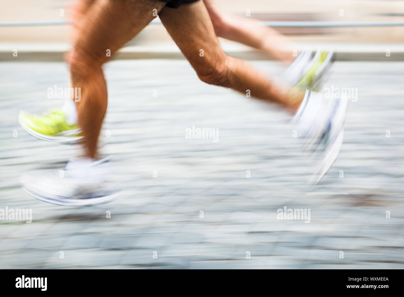 Motion blurred runner's feet in a city environment - running marathon ...