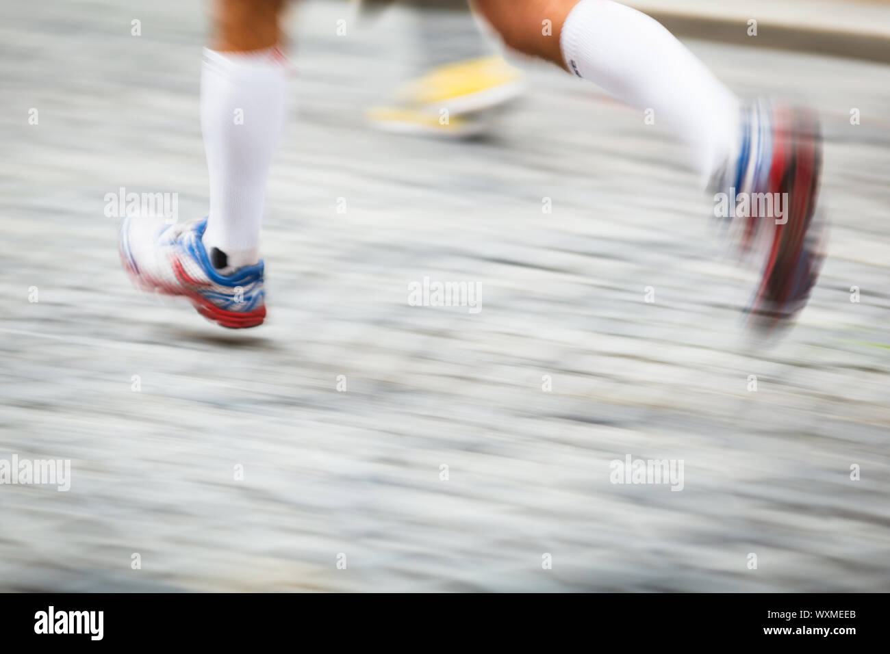 Motion blurred runner's feet in a city environment - running marathon ...