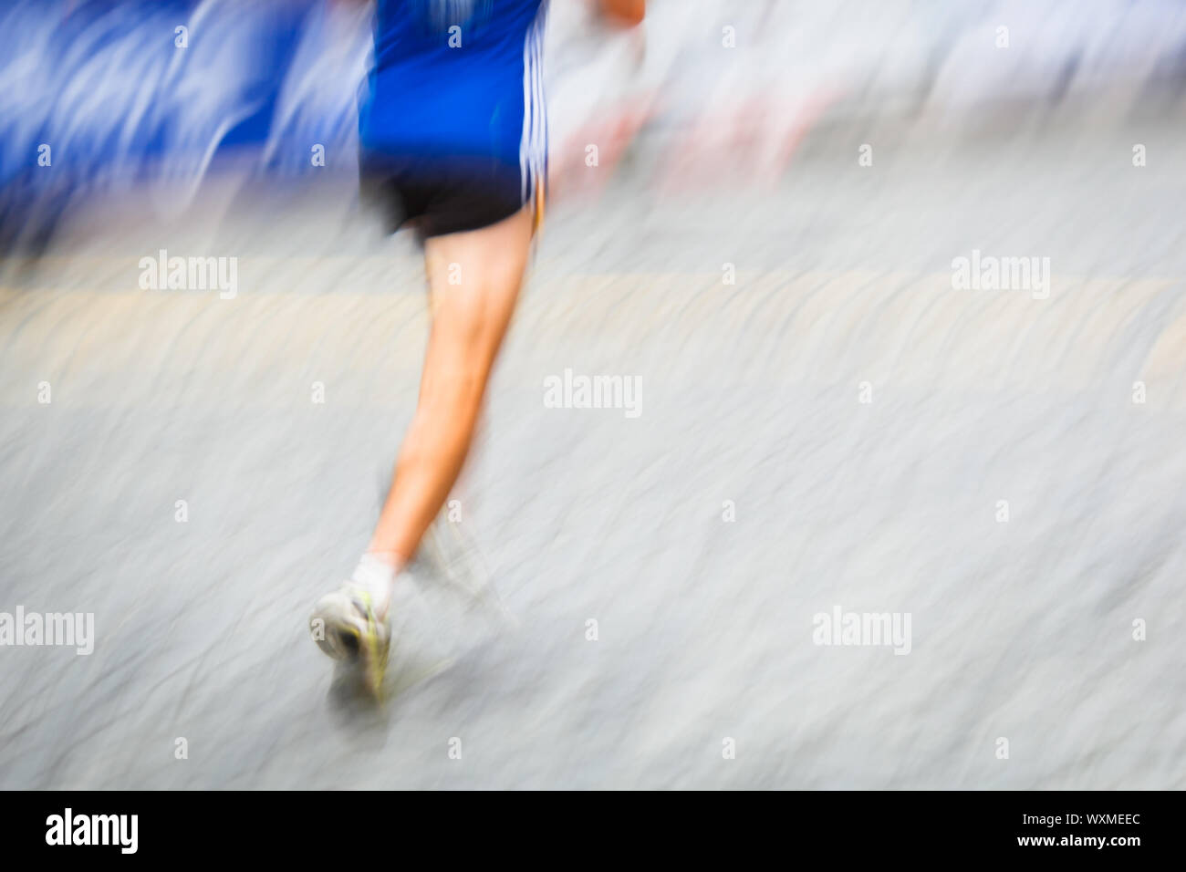 Motion blurred runner's feet in a city environment - running marathon ...