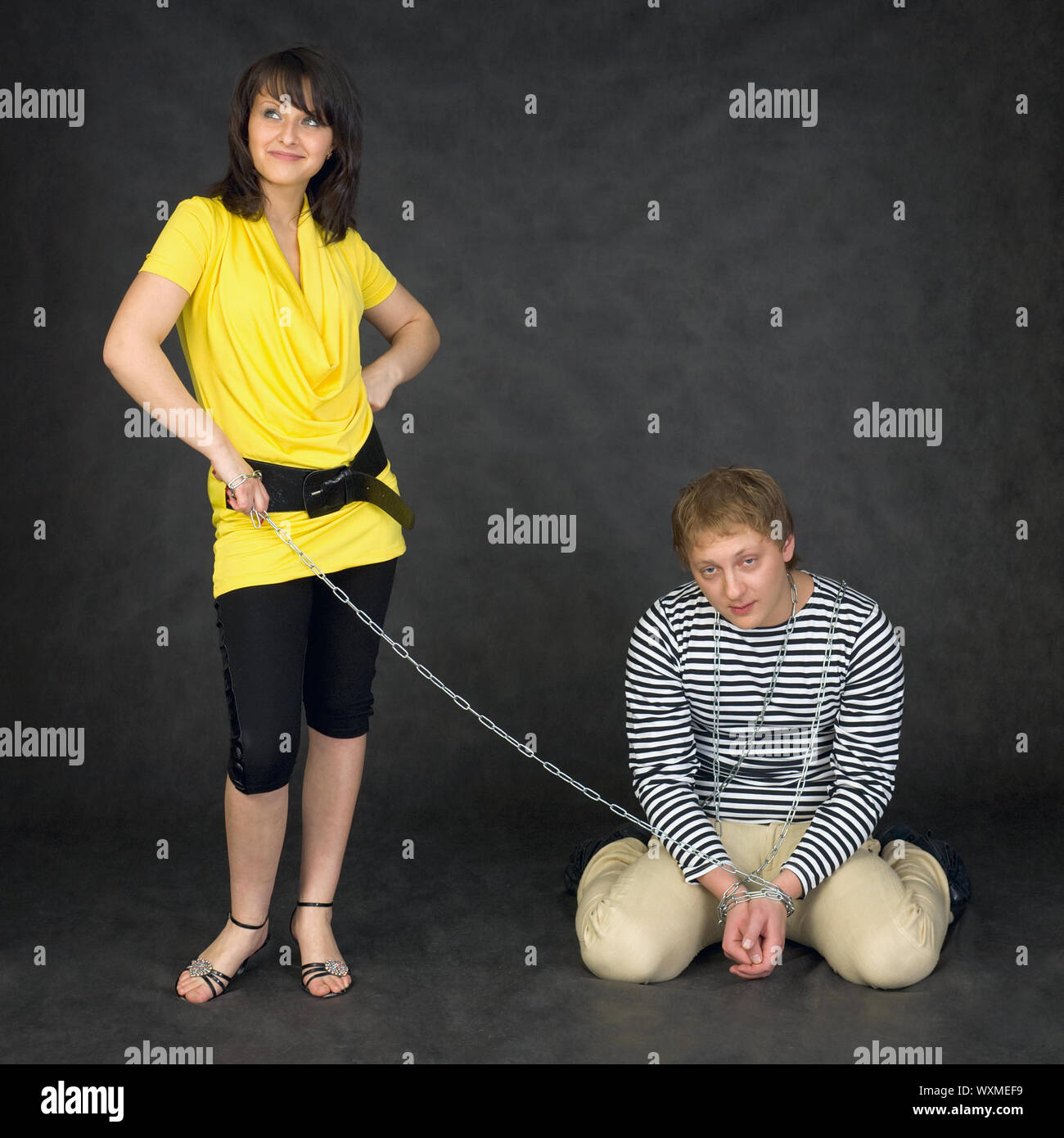 Guy chained in a chain and the girl Stock Photo - Alamy