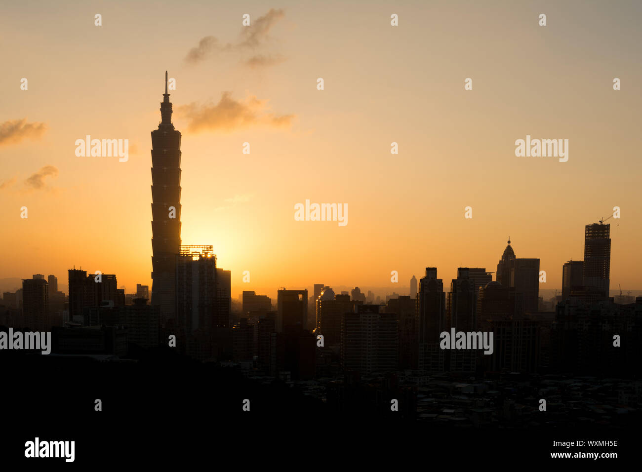 Sunset cityscape with silhouette of 101 skyscraper under dramatic ...