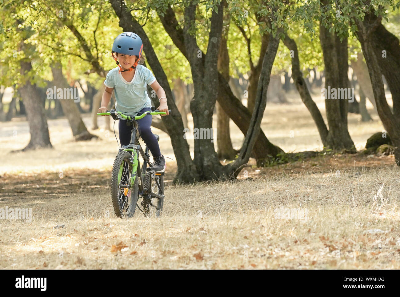 Children girl riding bicycle outdoor in forest Stock Photo - Alamy