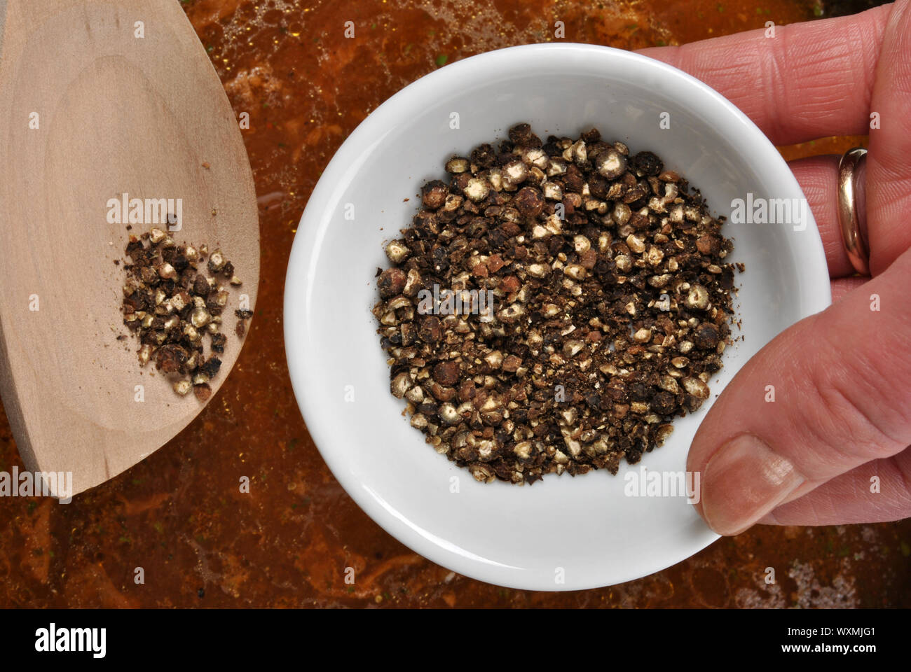 add some organic black pepper into a sauce Stock Photo - Alamy