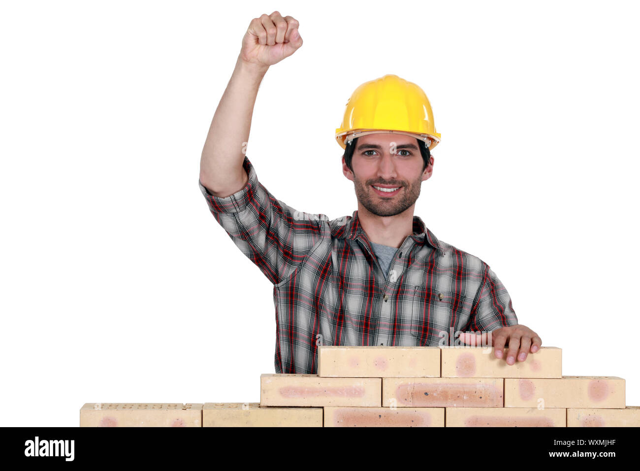Happy mason lifting fist Stock Photo - Alamy