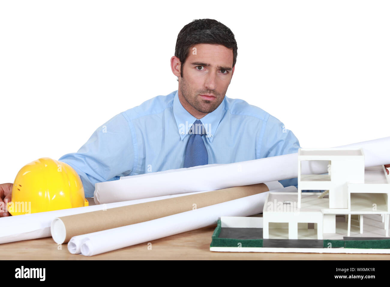 handsome architect posing near model and blueprints Stock Photo - Alamy