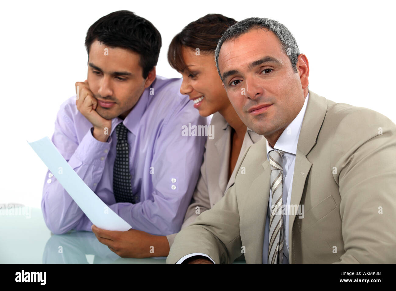 Workers sitting around a table Stock Photo - Alamy