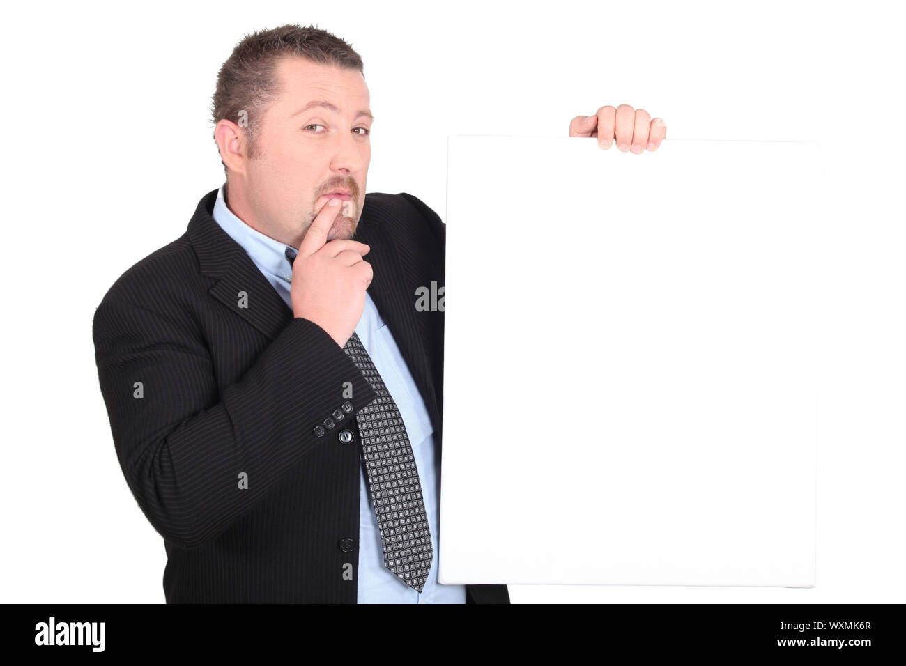 Perplexed man with white sign Stock Photo - Alamy
