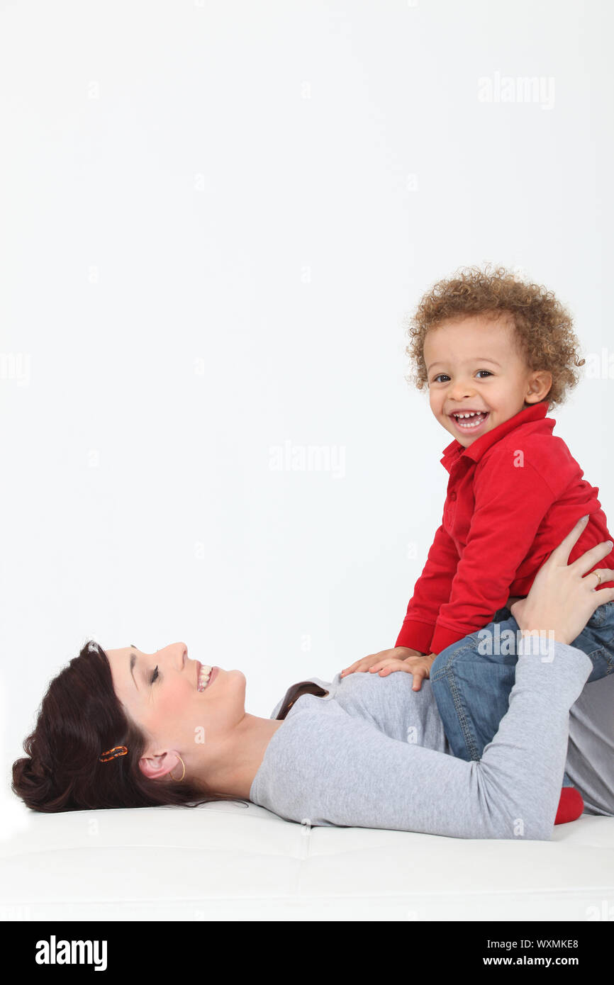 Mother resting son on belly Stock Photo - Alamy